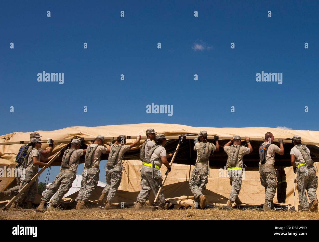 U.S. Air Force and Army personnel stand up a roof frame of a Utilis TM ...