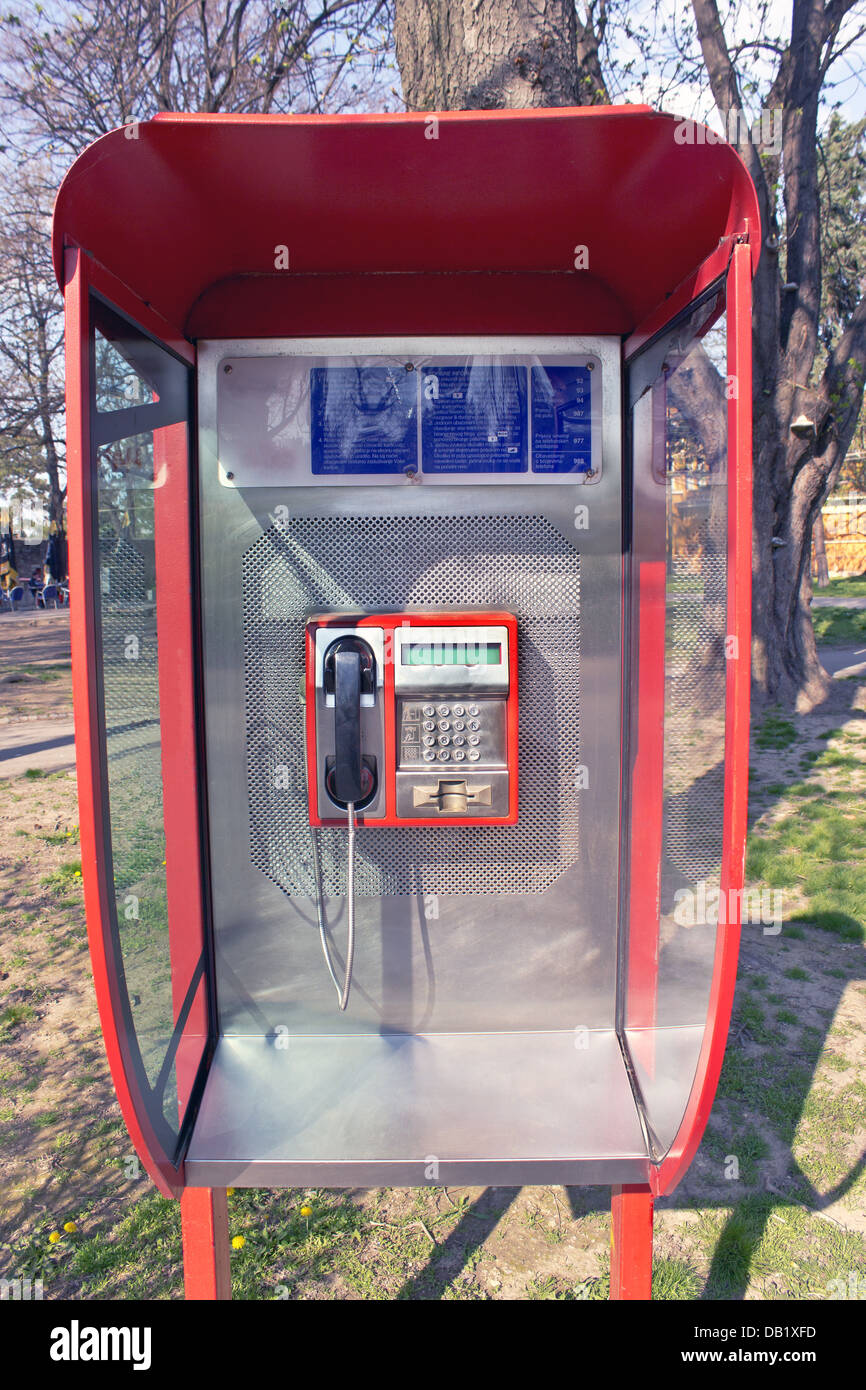 Orange public telephone on metallic background in park Stock Photo - Alamy