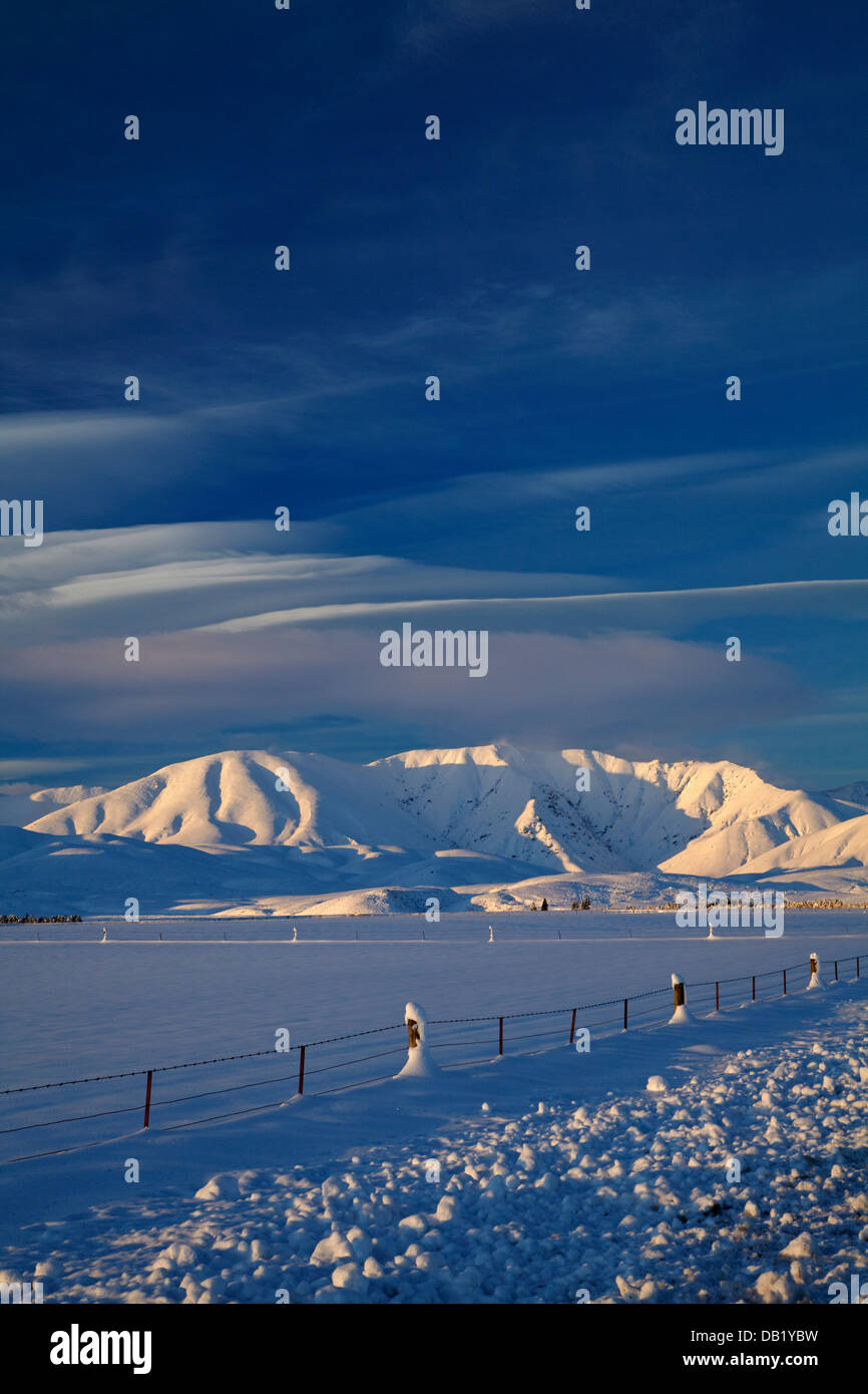 Last light on snowy farmland and Hawkdun Range, Maniototo, Central Otago, South Island, New ...