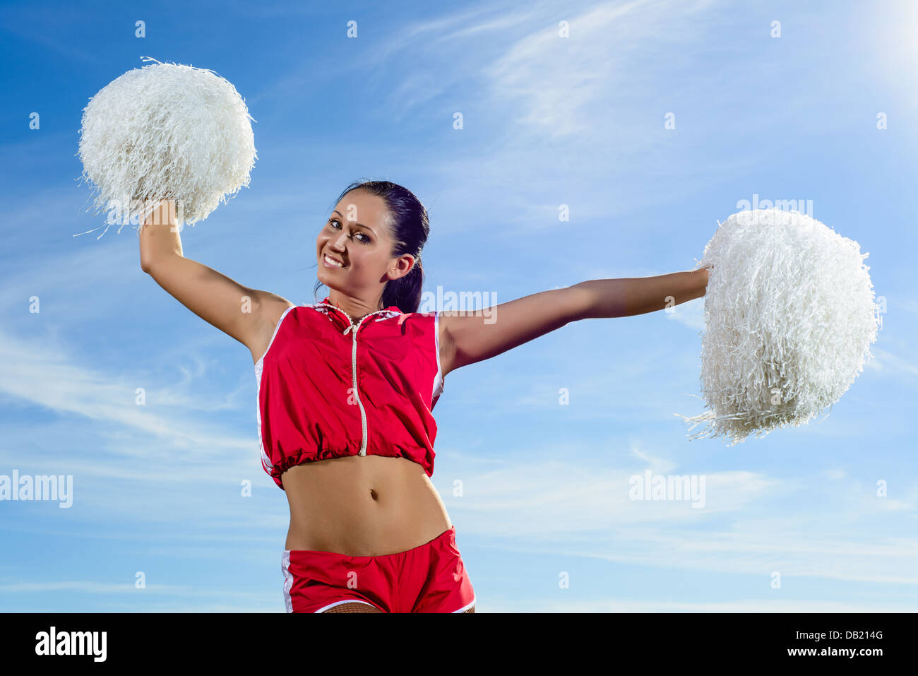 Young cheerleader in red costume with pampon Stock Photo - Alamy