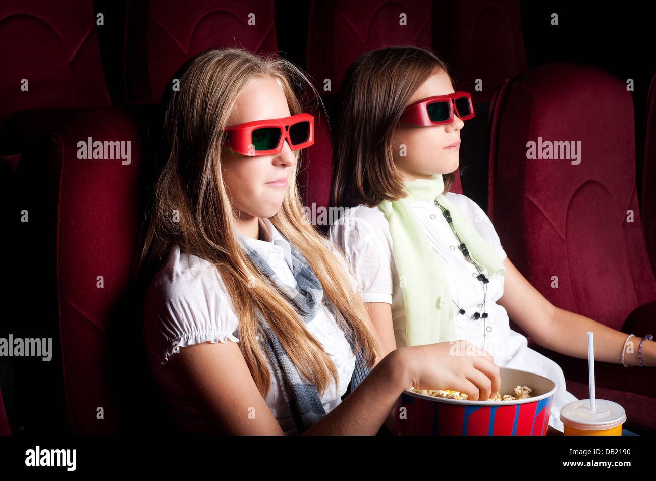 two beautiful girls watching a movie at the cinema Stock Photo - Alamy