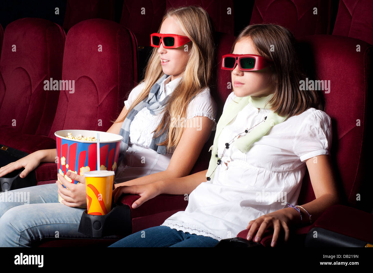 two beautiful girls watching a movie at the cinema Stock Photo - Alamy