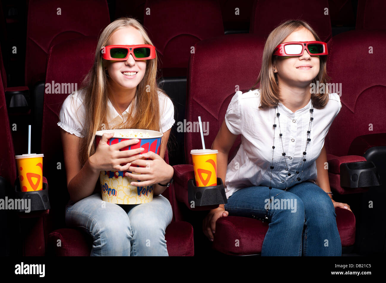 two beautiful girls watching a movie at the cinema Stock Photo - Alamy