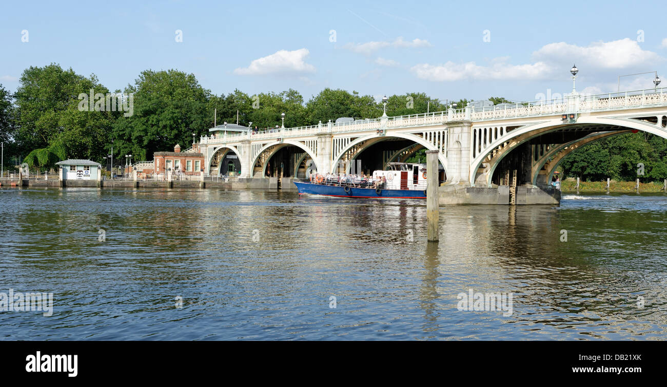 Sightseeing tourist boat emerging from under an arch of Richmond Lock ...