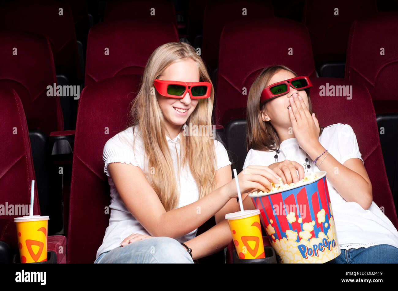 two beautiful girls watching a movie at the cinema Stock Photo - Alamy
