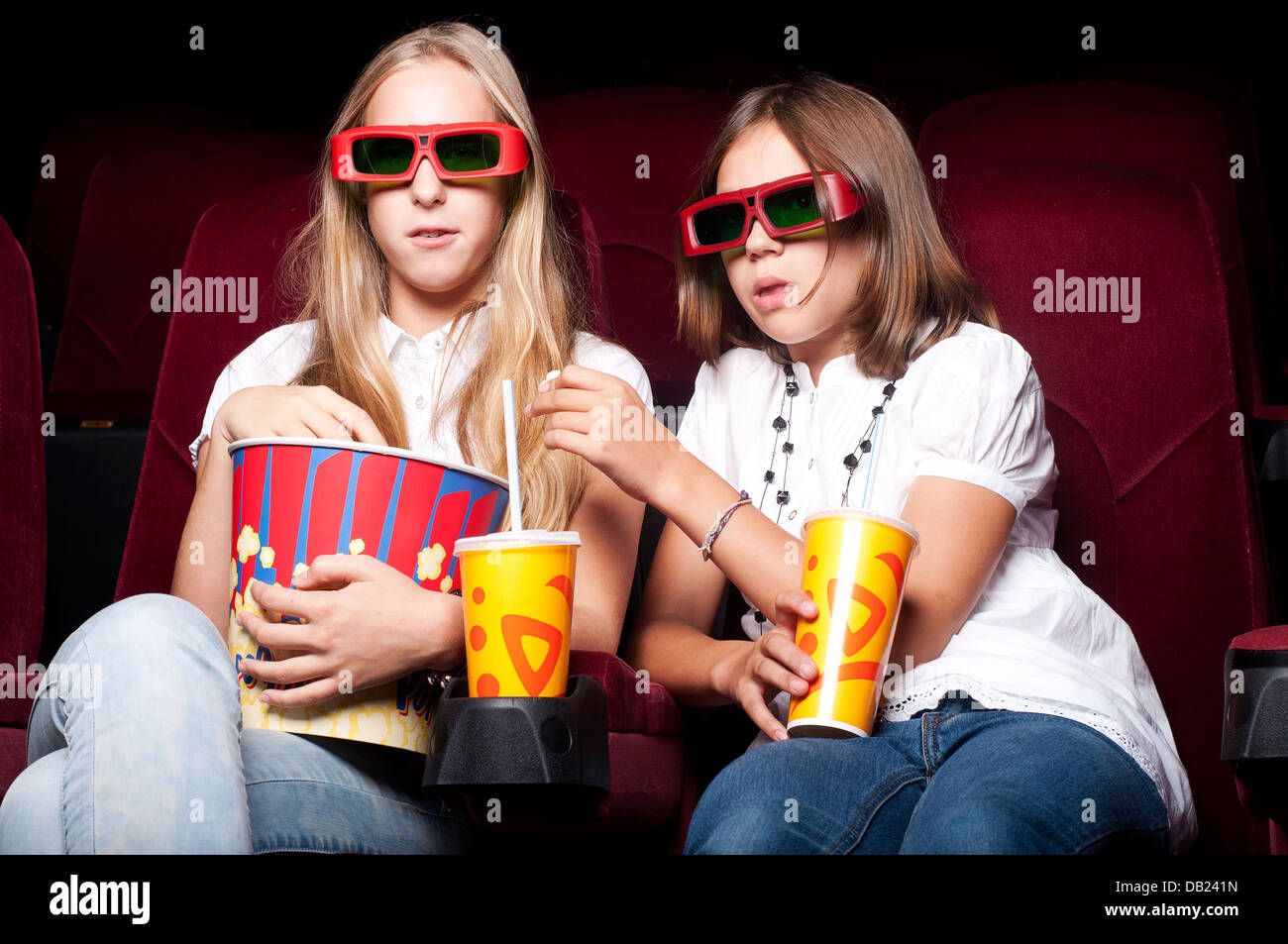 two beautiful girls watching a movie at the cinema Stock Photo - Alamy