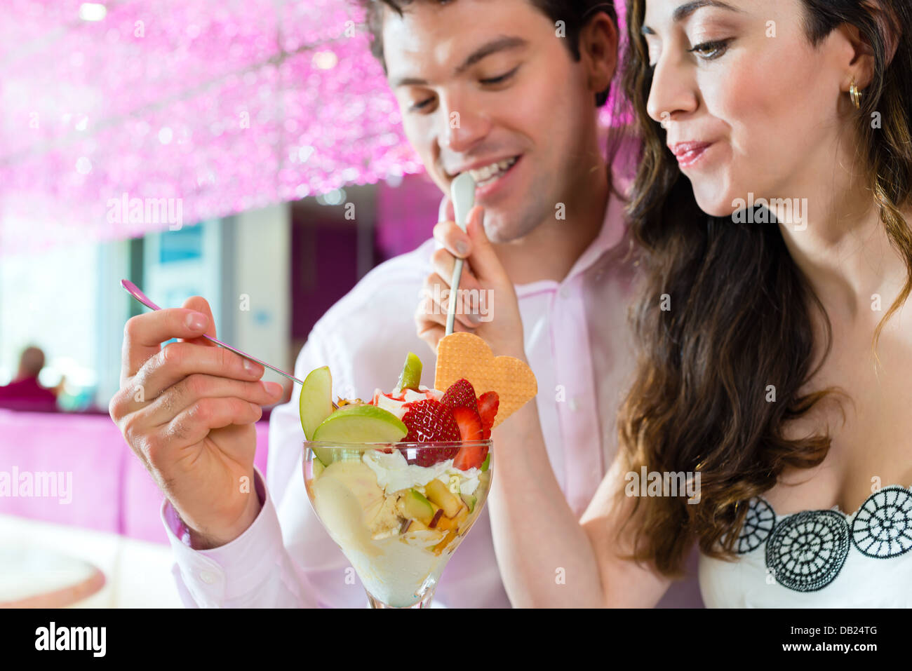 Young Couple in a Cafe or Ice cream parlor, eating an ice cream sundae ...