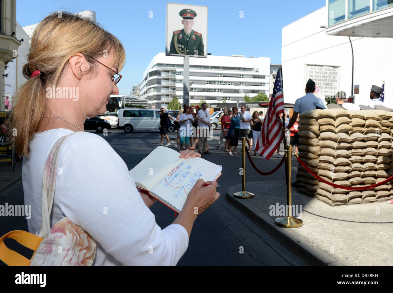Artist Anja Rieger draws a scene at Checkpoint Charlie in Berlin ...