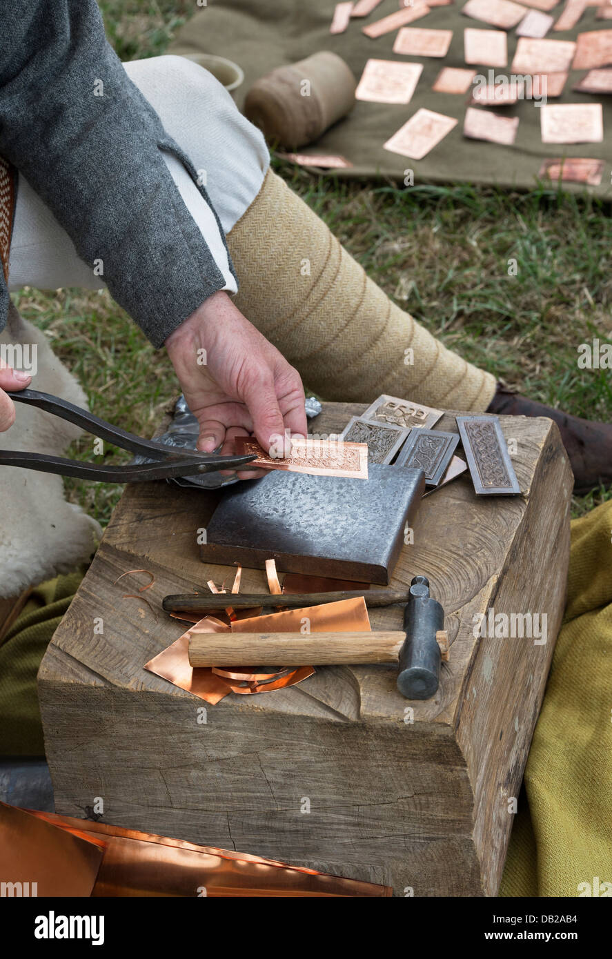 Skilled craftsman making replica Anglo Saxon designs onto copper sheet ...