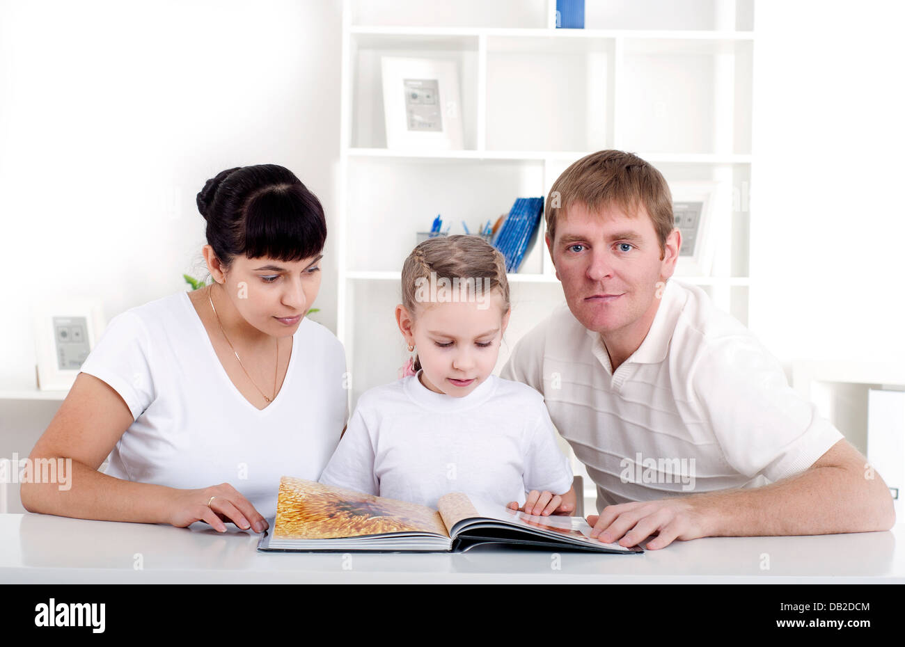 Family reading a book together Stock Photo - Alamy