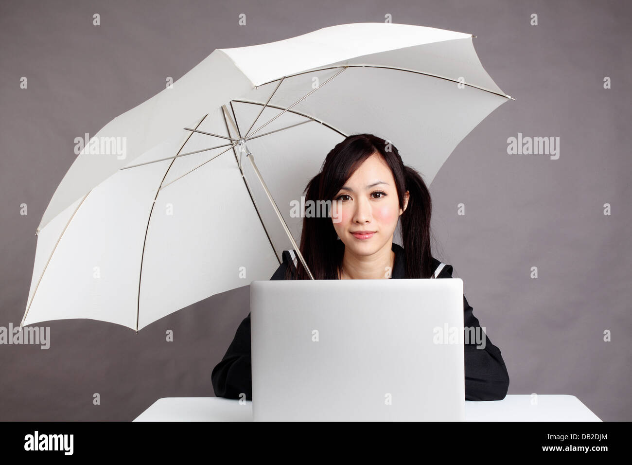 School girl is using computer under white umbrella Stock Photo - Alamy