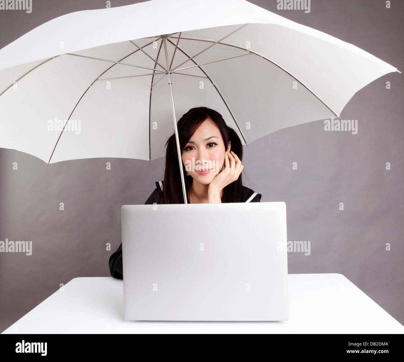 School girl is using computer under white umbrella Stock Photo - Alamy