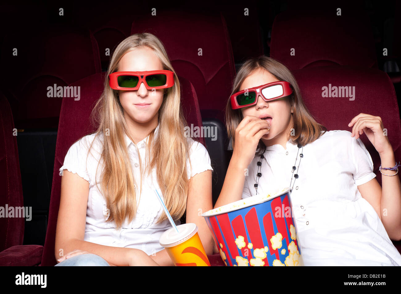 two beautiful girls watching a movie at the cinema Stock Photo - Alamy