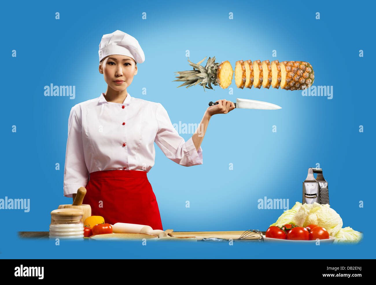 Asian female chef cuts pineapple Stock Photo - Alamy