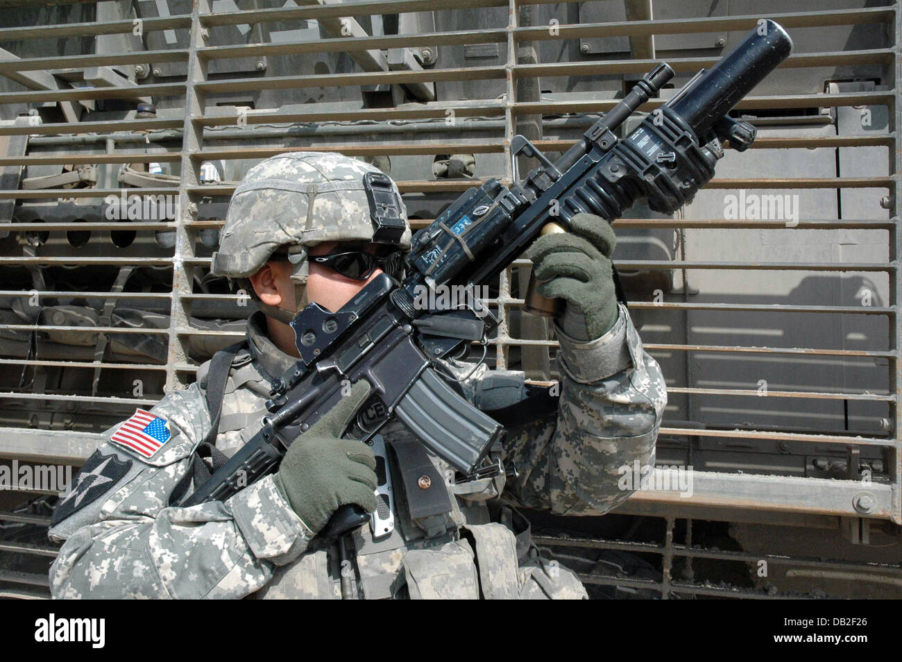 A foot soldier stands guard with his M4A1 carbine featuring a M203 ...