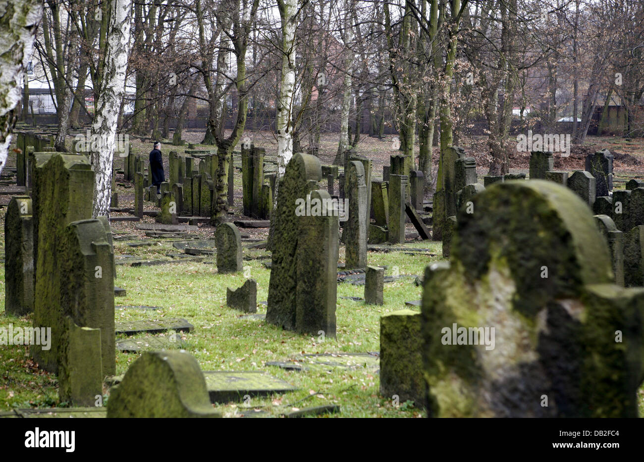 A visitor walks past gravestones and memorial plates at the re-opened ...