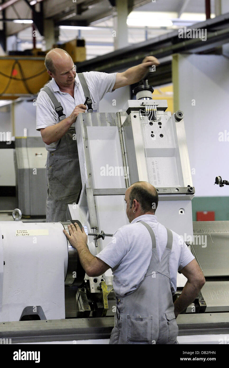 The picture shows two workers as they carry out maintenance work at a ...