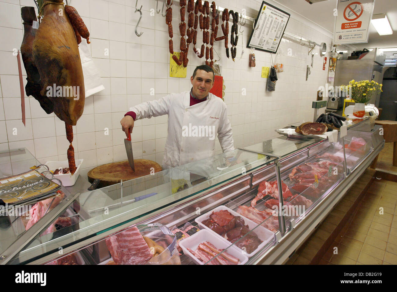 A butcher poses behind the meat counter at his butcher's shop in Porto ...