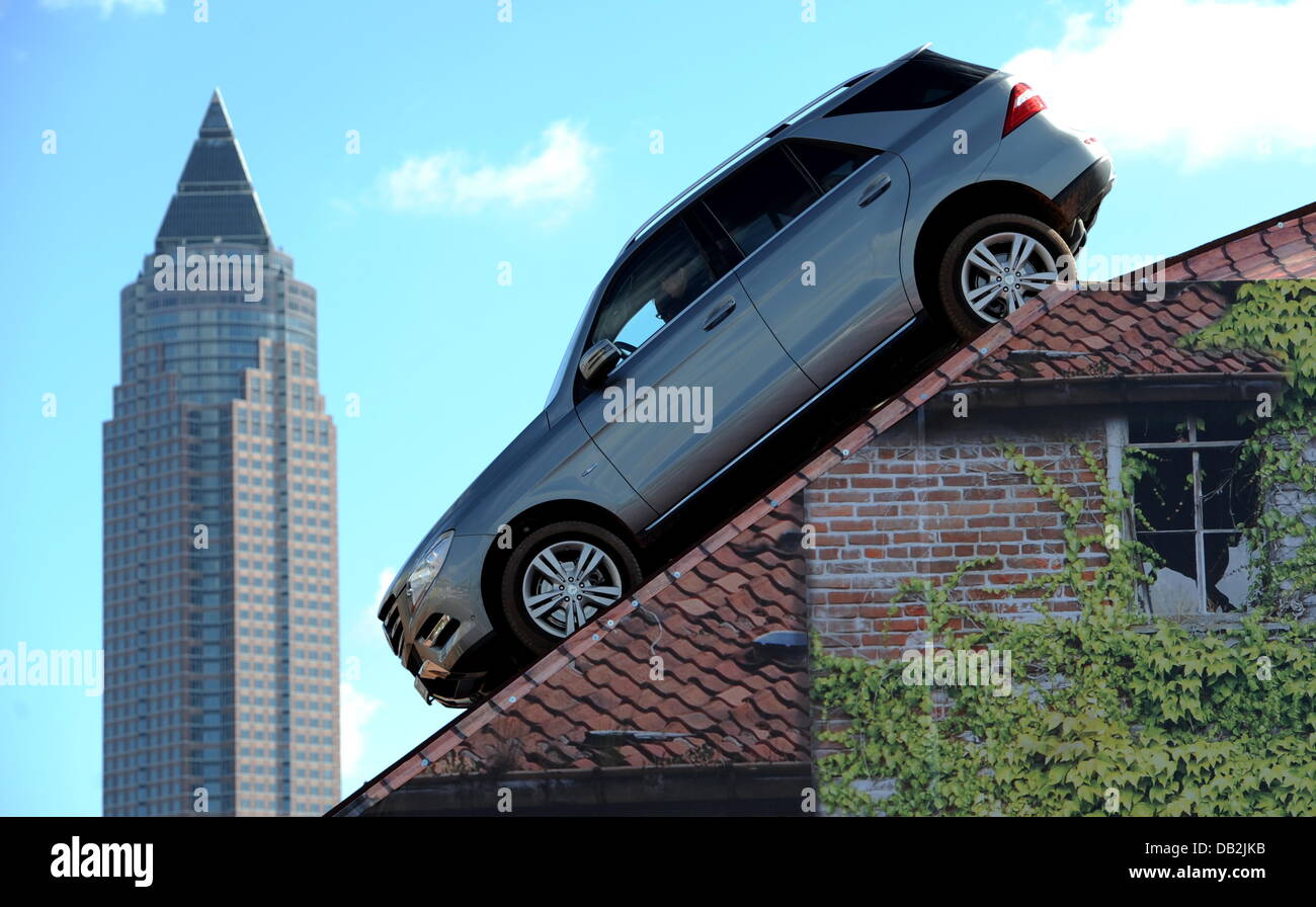 A Mercedes ML drives down a steep incline in front of the fair's tower ...