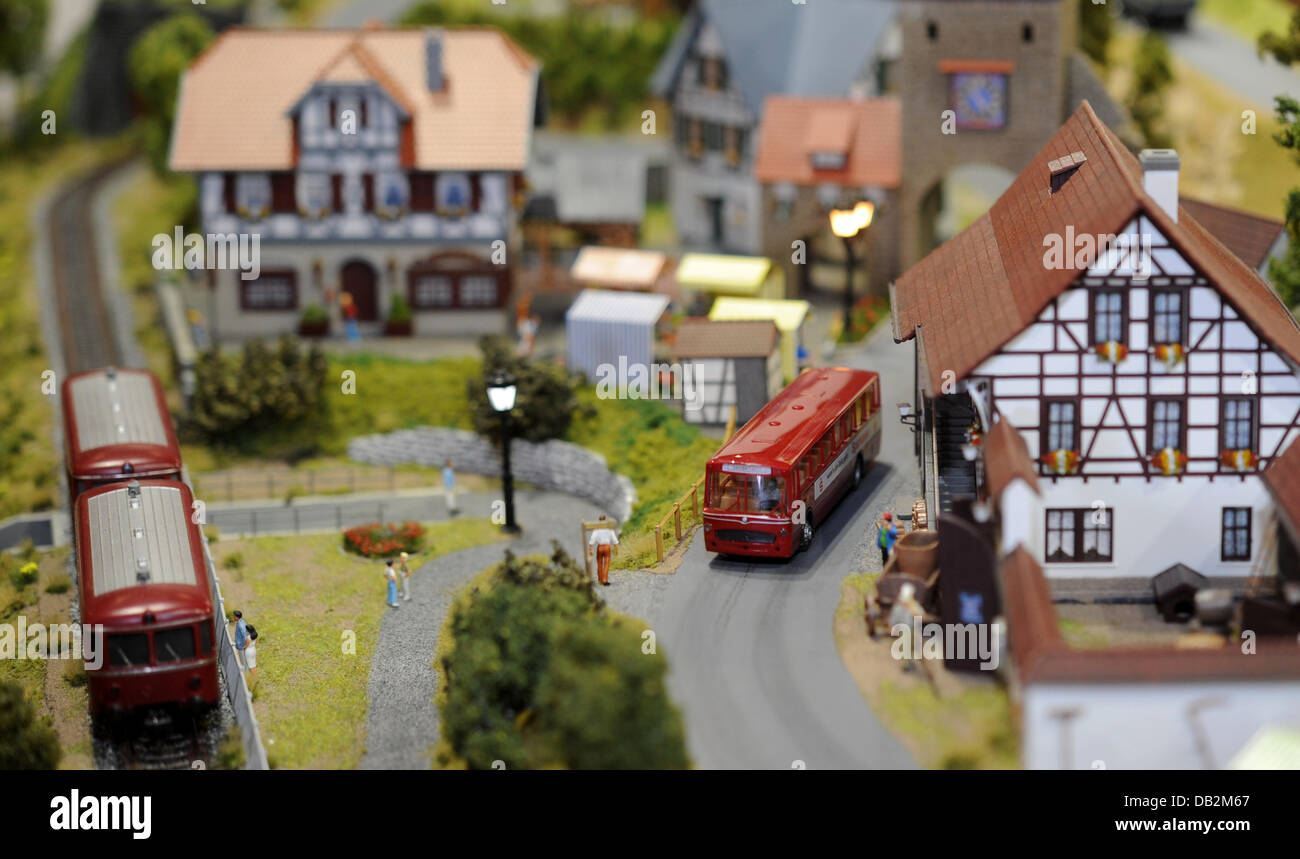 An electric model bus drives through a model train installation by the ...