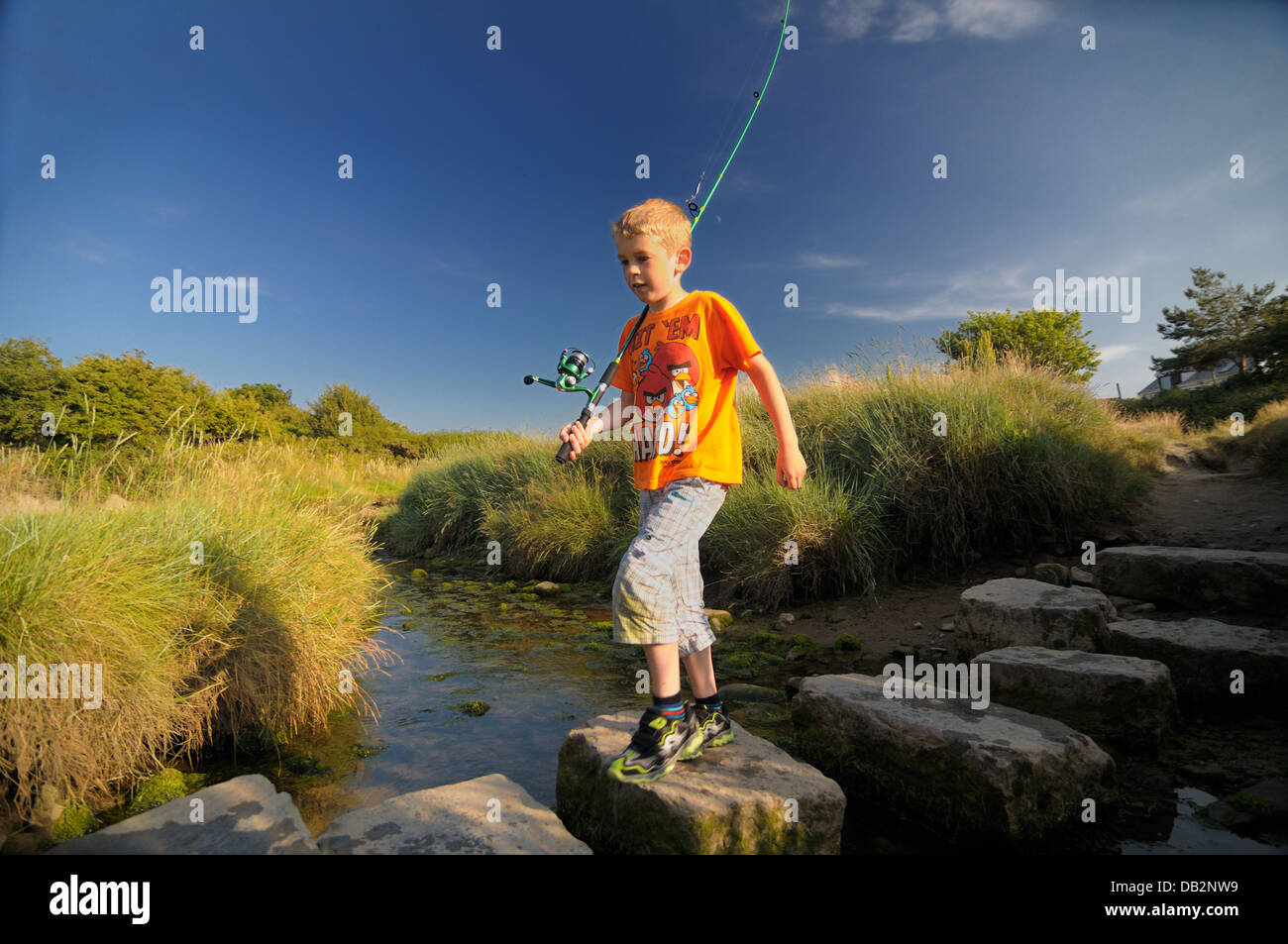 young boy fishing crossing stepping stones river teifi estuary poppit ...