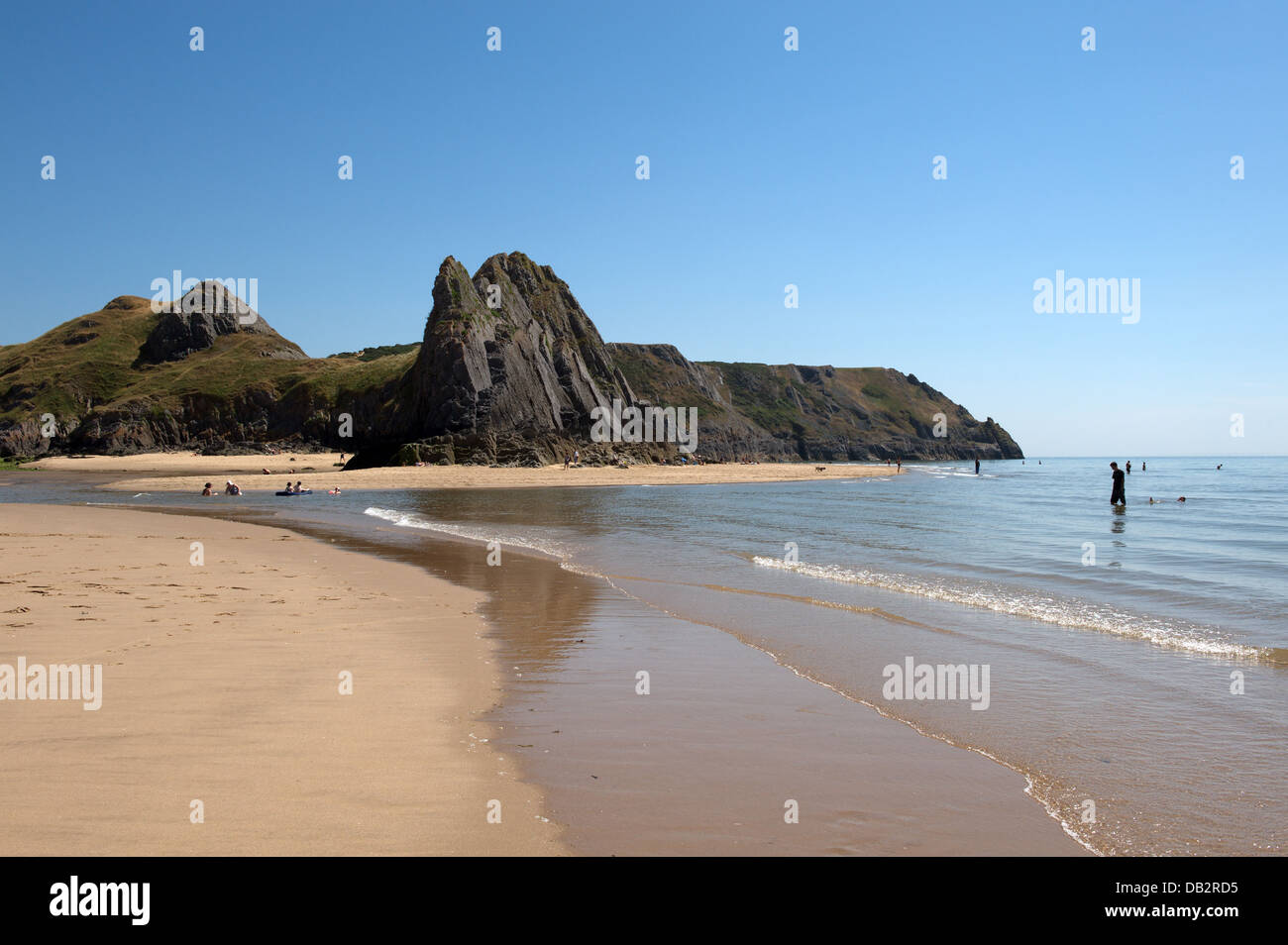 Three cliffs beach with swimmers in shallow blue sea Stock Photo - Alamy