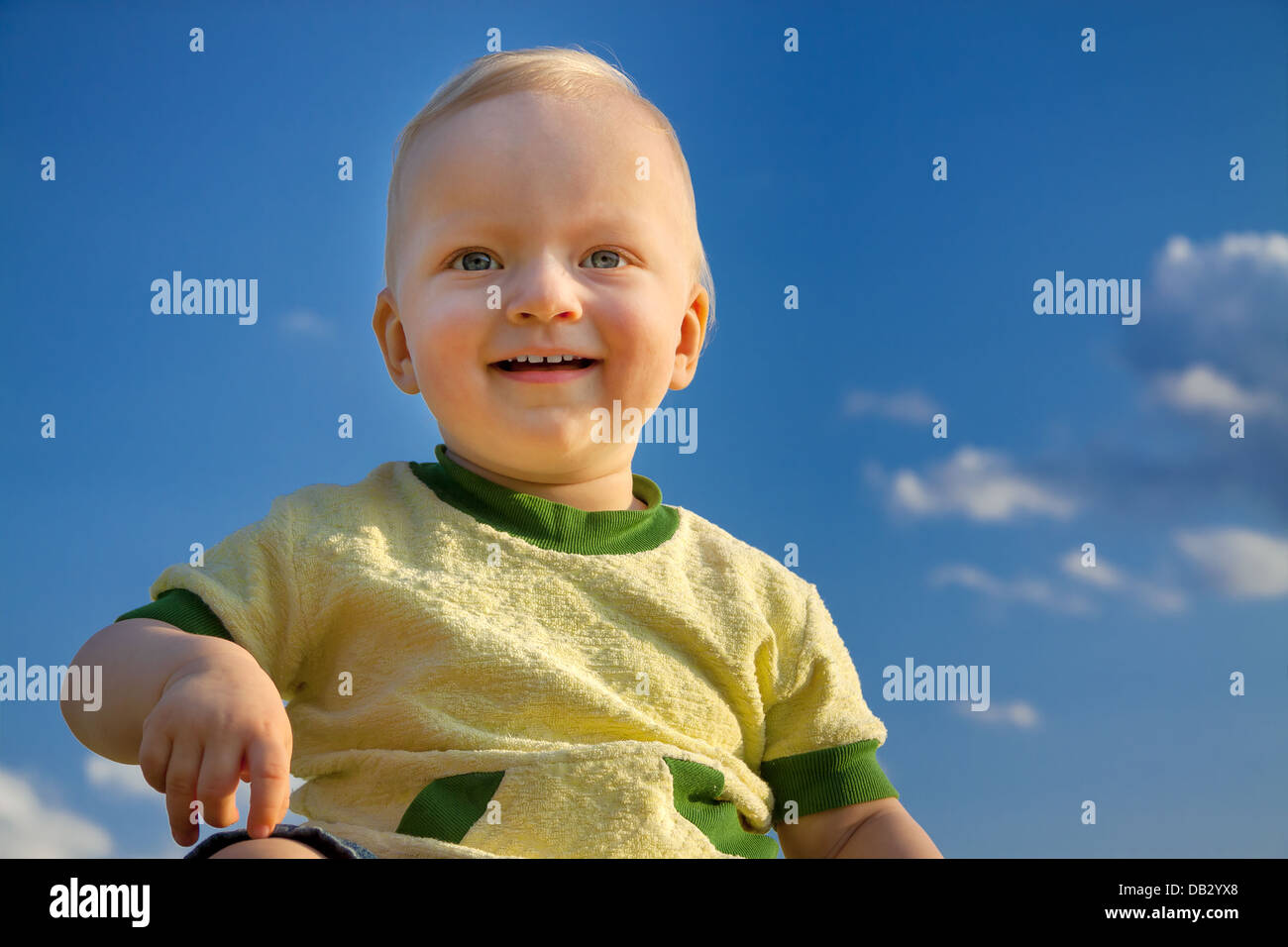 the beautiful small child smiling against the blue sky Stock Photo - Alamy