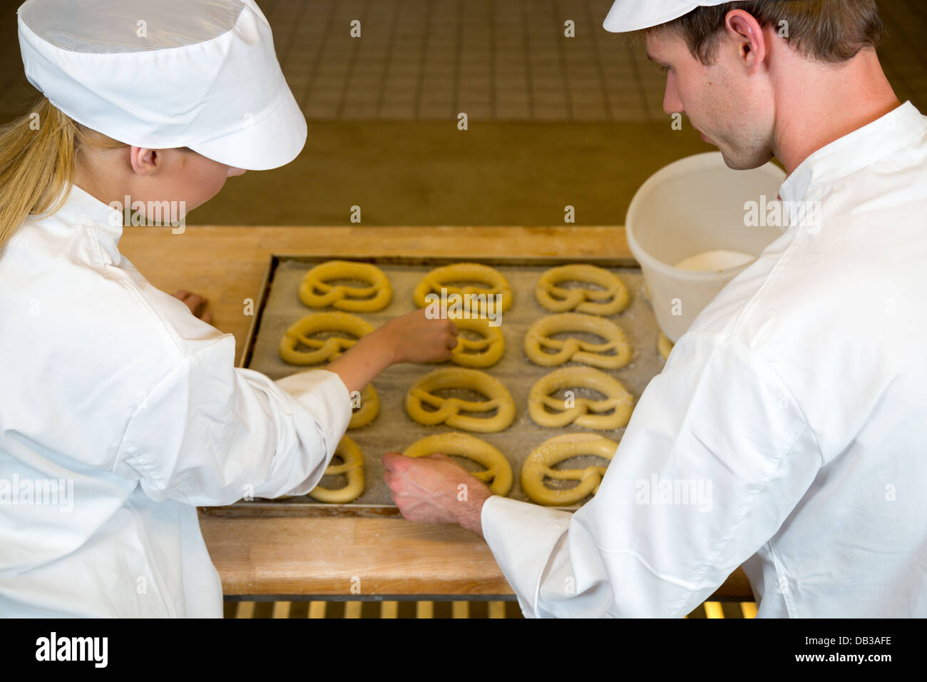 Two bakers in bakery or bakehouse baking pretzels Stock Photo - Alamy