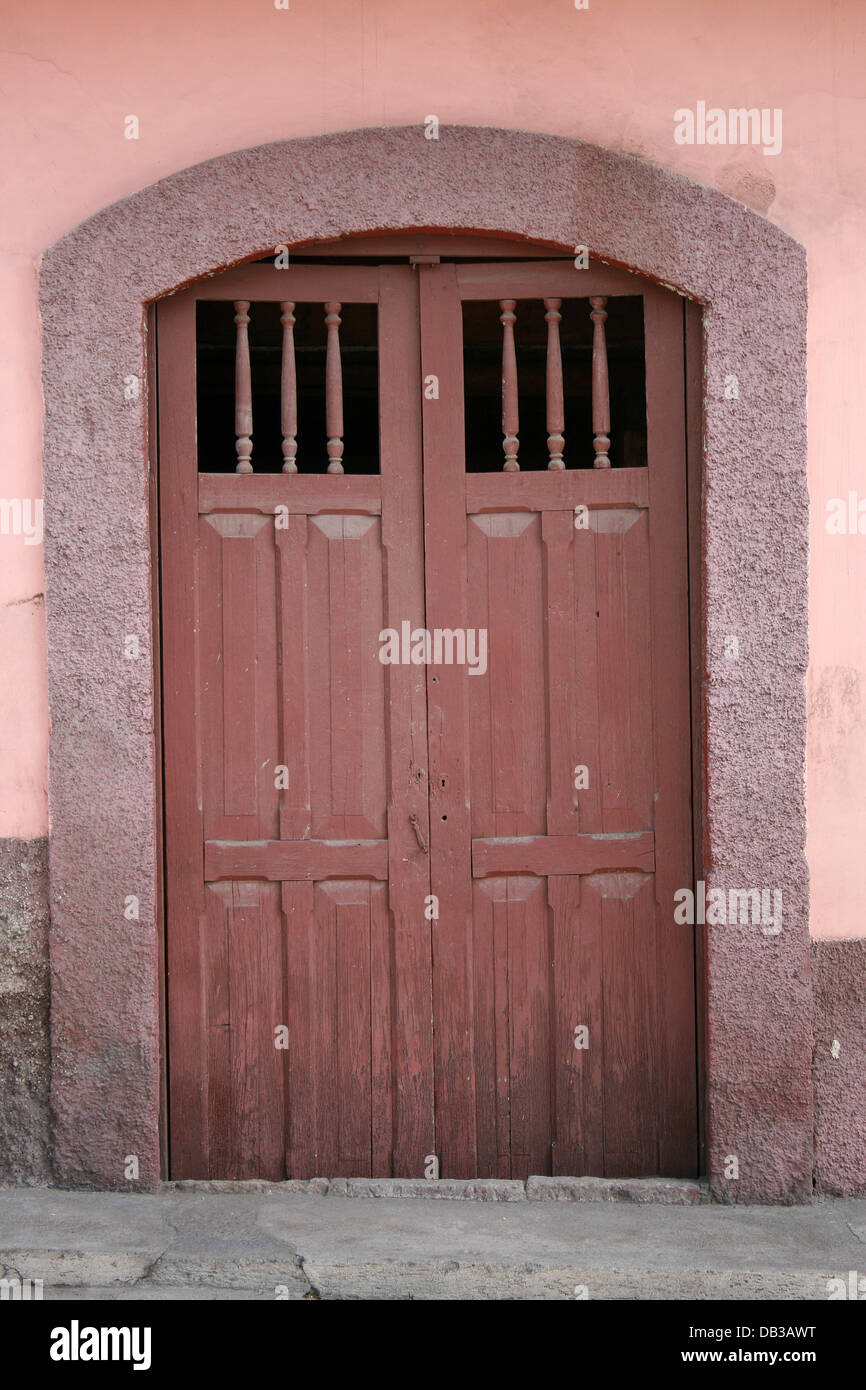 A wood panel door set in a concrete wall in a building in Cotacachi ...