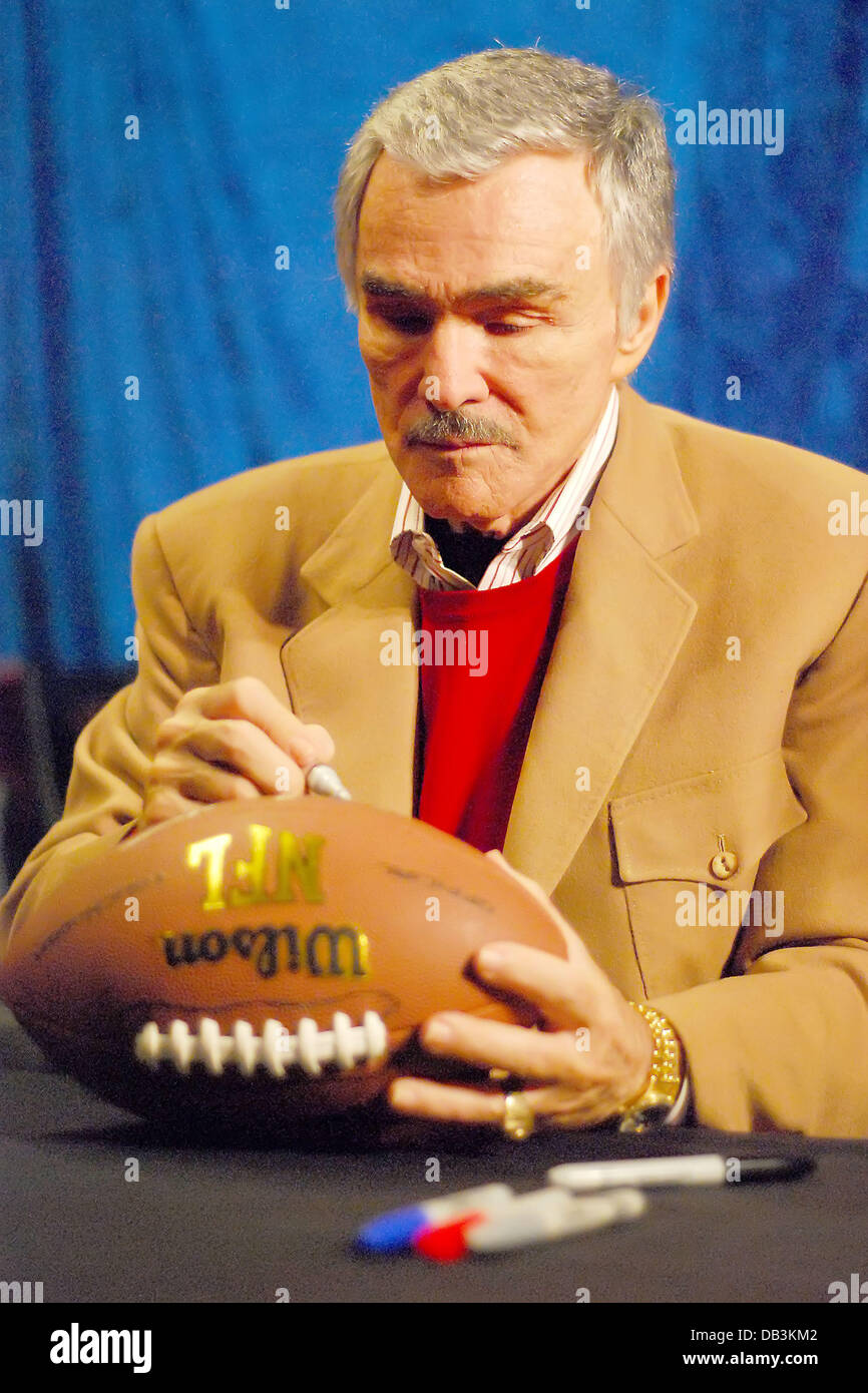 Burt Reynolds signs a football during a special appearance at Hollywood ...