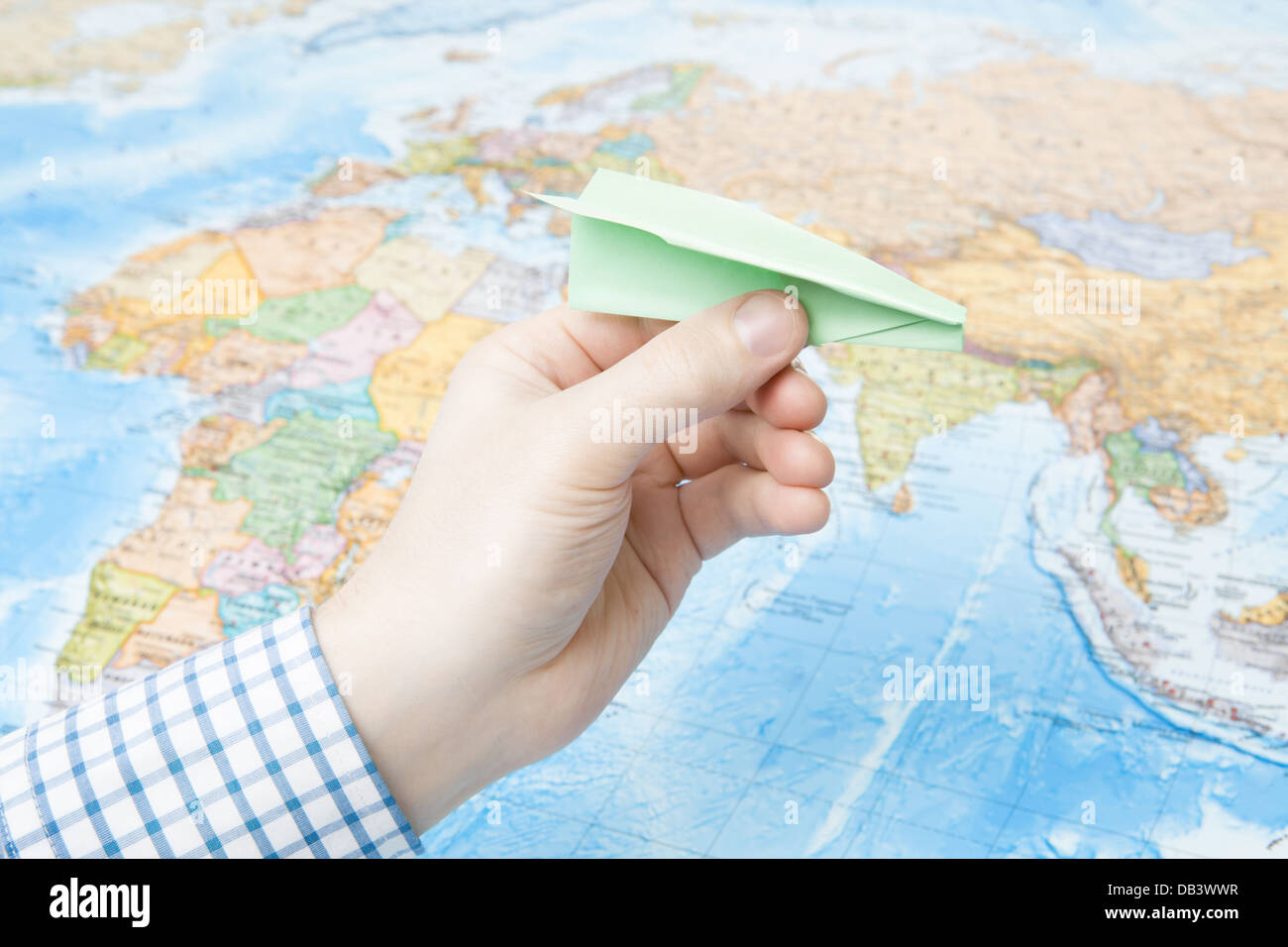 Paper plane in hand with world map on background Stock Photo - Alamy