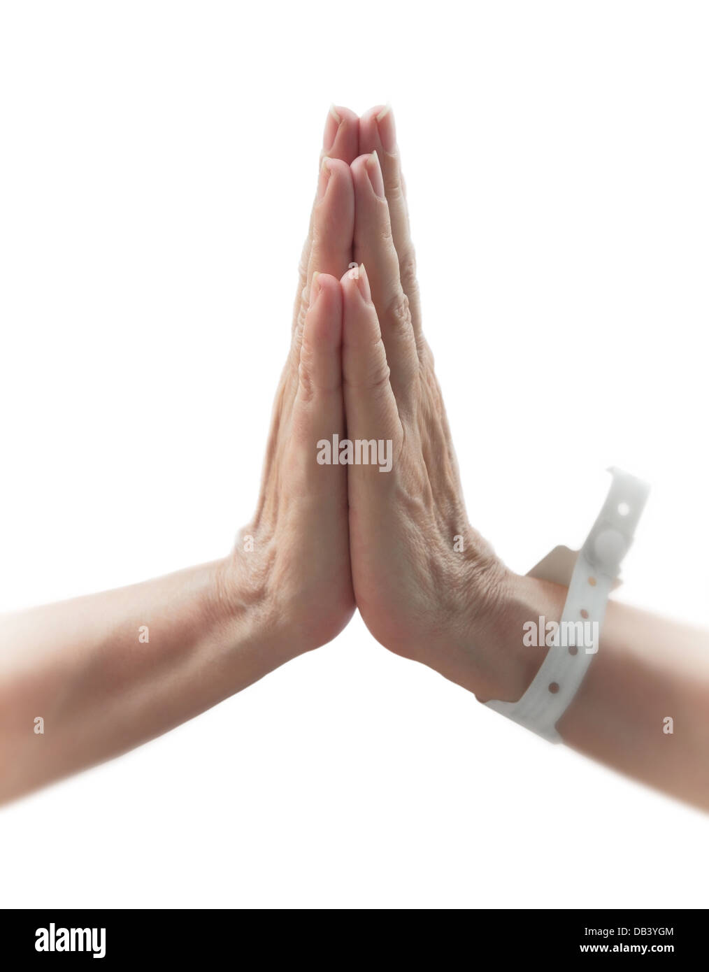 hands folded in prayer with a hospital ID bracelet on the left wrist ...