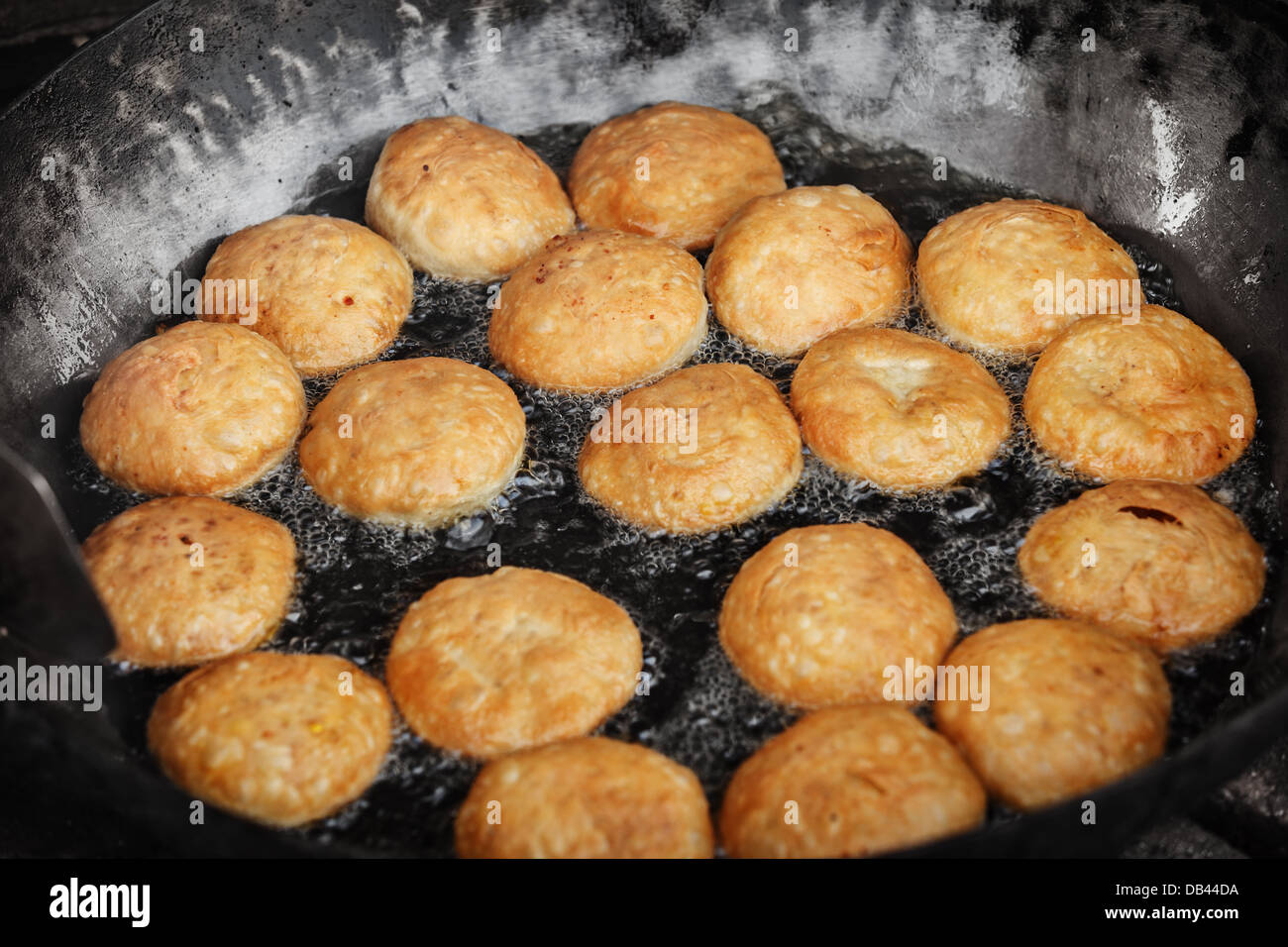 Indian pastries in a pan with oil on the open market Stock Photo - Alamy