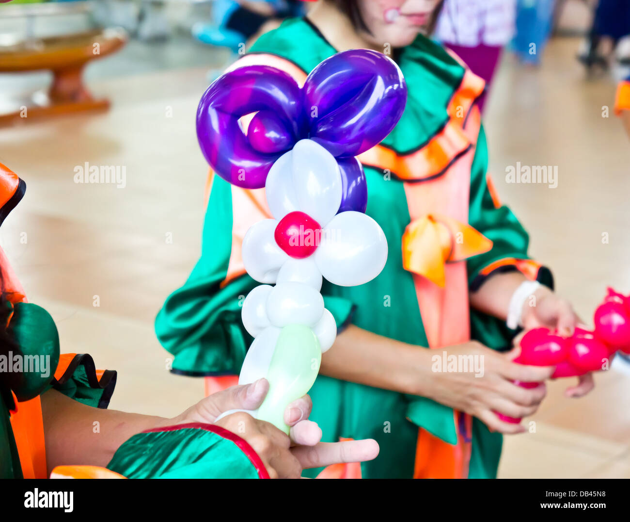 The clowns are twisting balloons for kid Stock Photo - Alamy