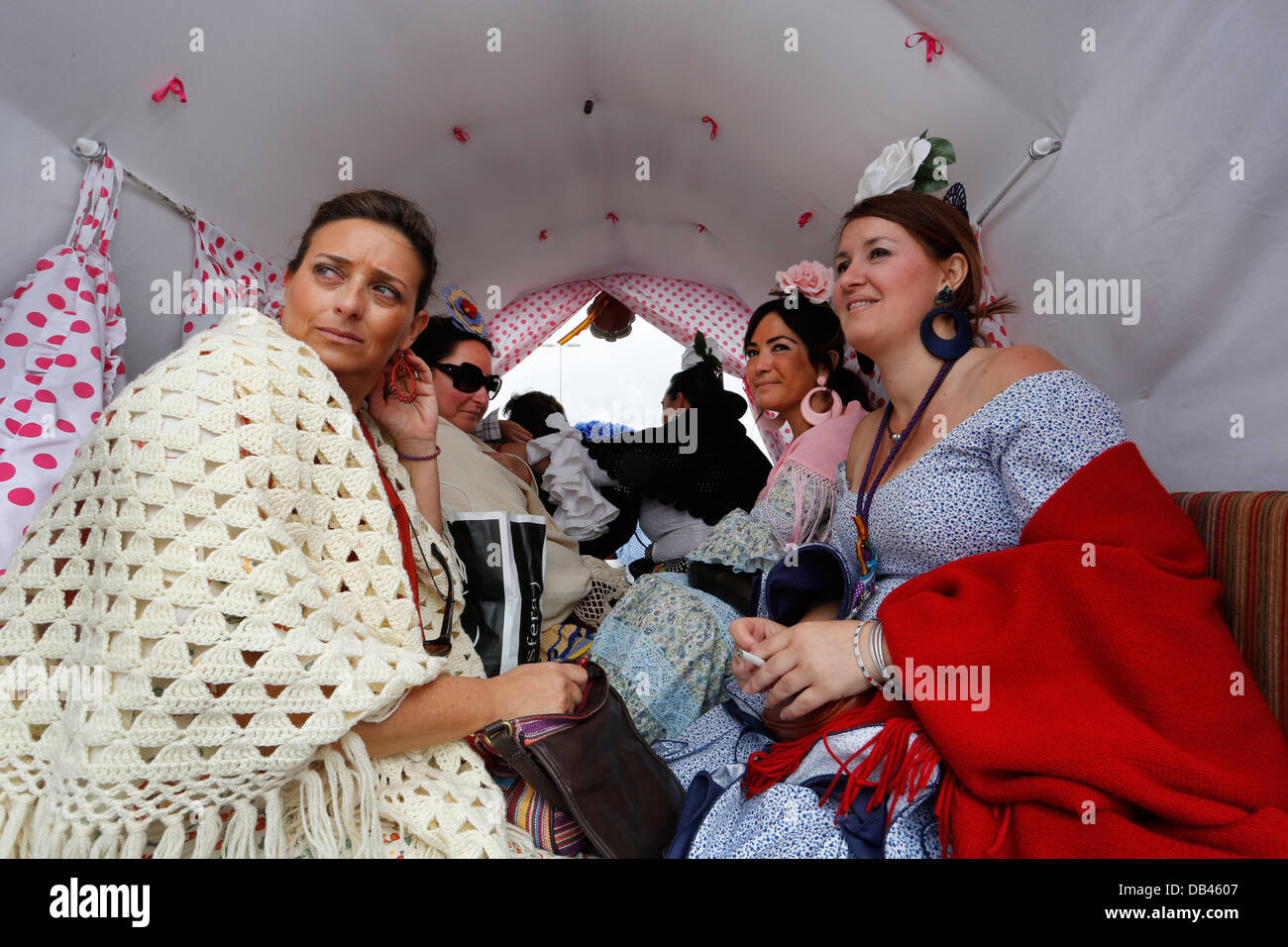 Women wearing Spanish Flamenco dresses in gypsy horse-drawn carriages ...