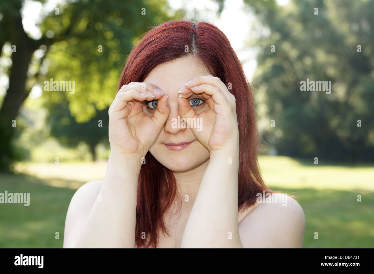 young woman imitating binoculars with her fingers around her eyes Stock ...