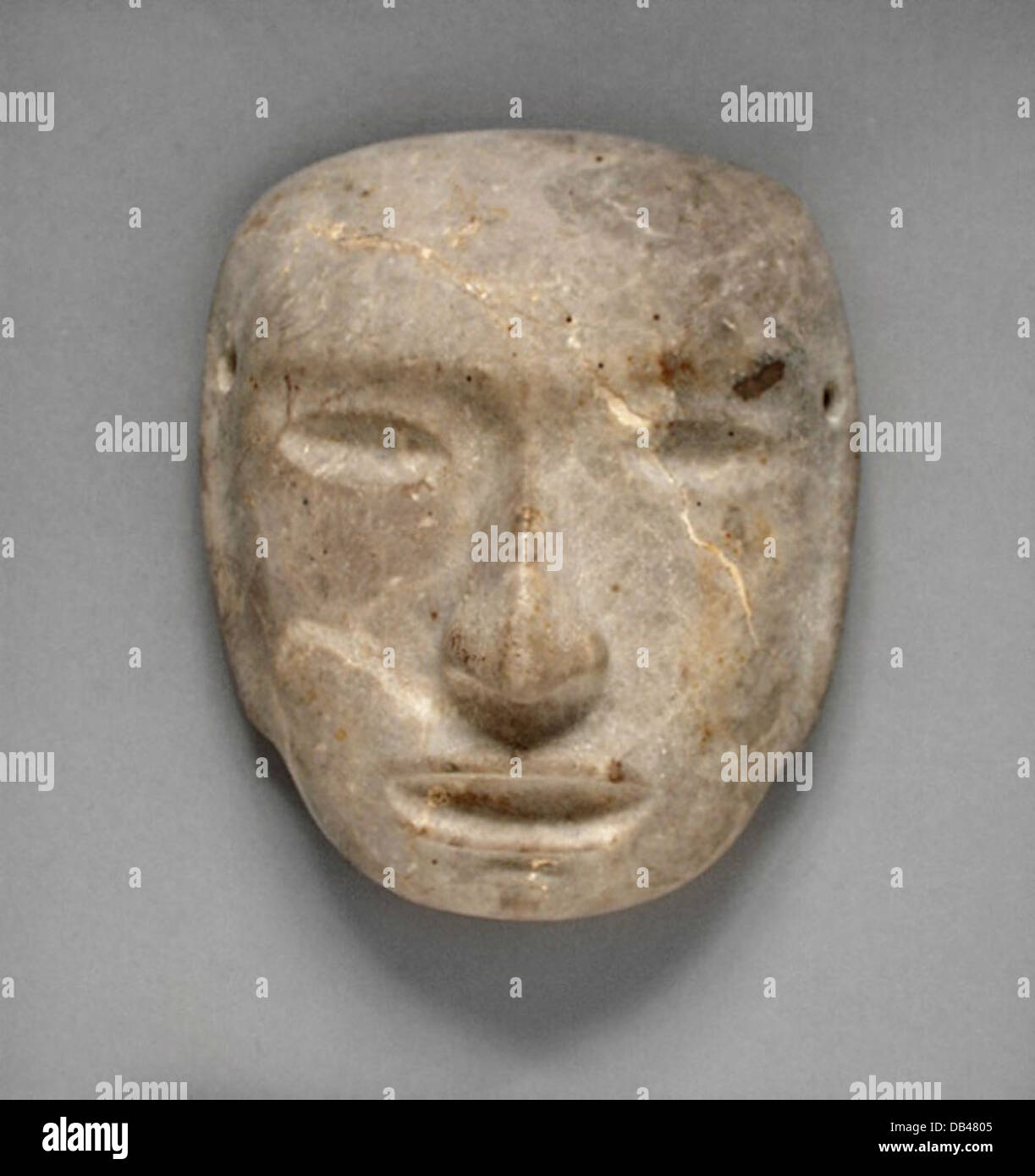 A carved mask representing a cultural or ritualistic tradition ...