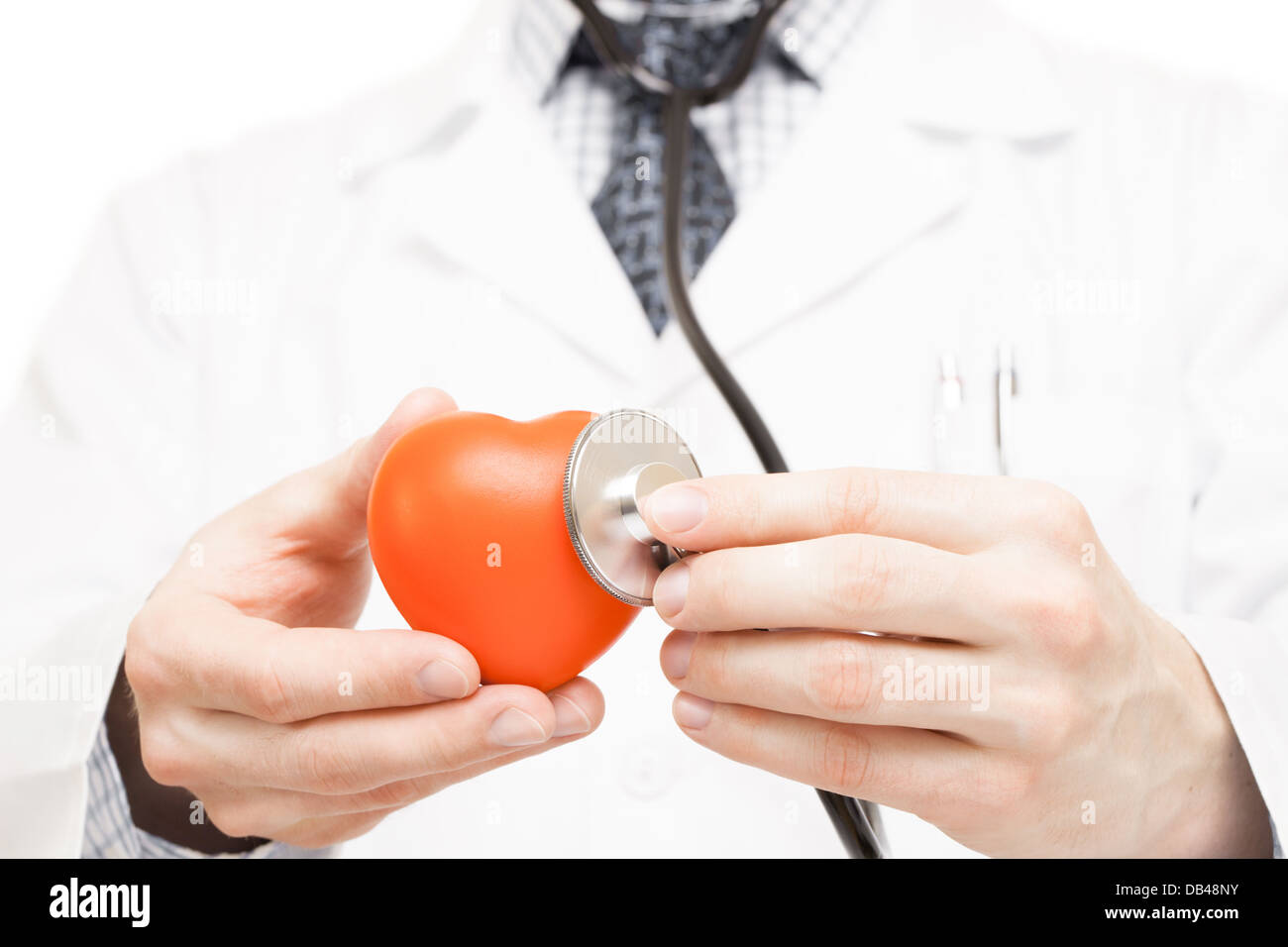 Doctor examining a heart toy on white background Stock Photo - Alamy