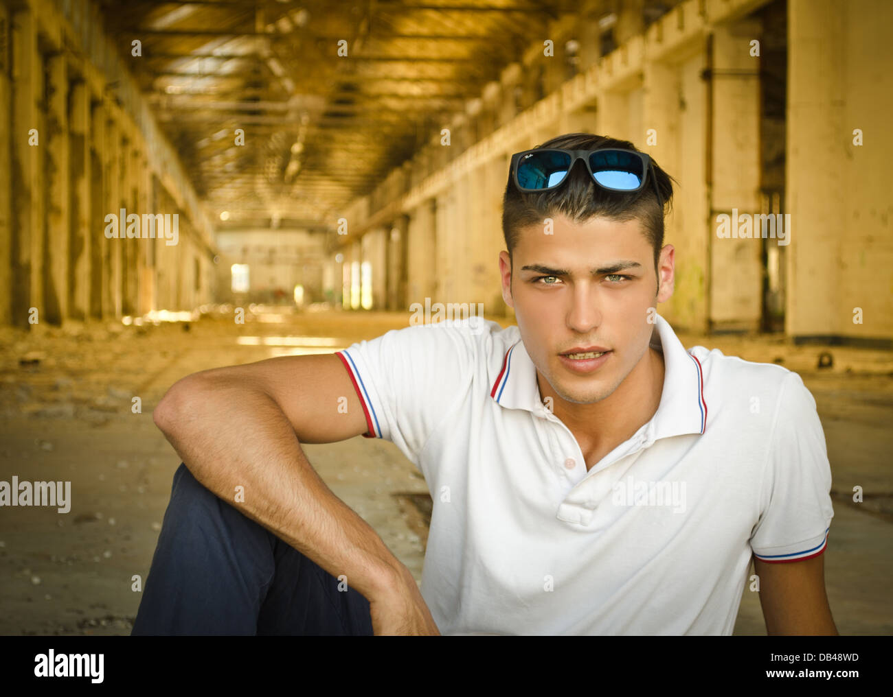 Handsome young man in abandoned, empty warehouse or old factory Stock ...