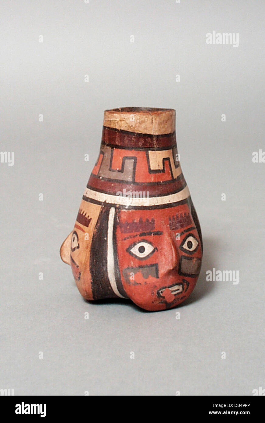 This miniature jar features three heads as part of its design. The jar ...