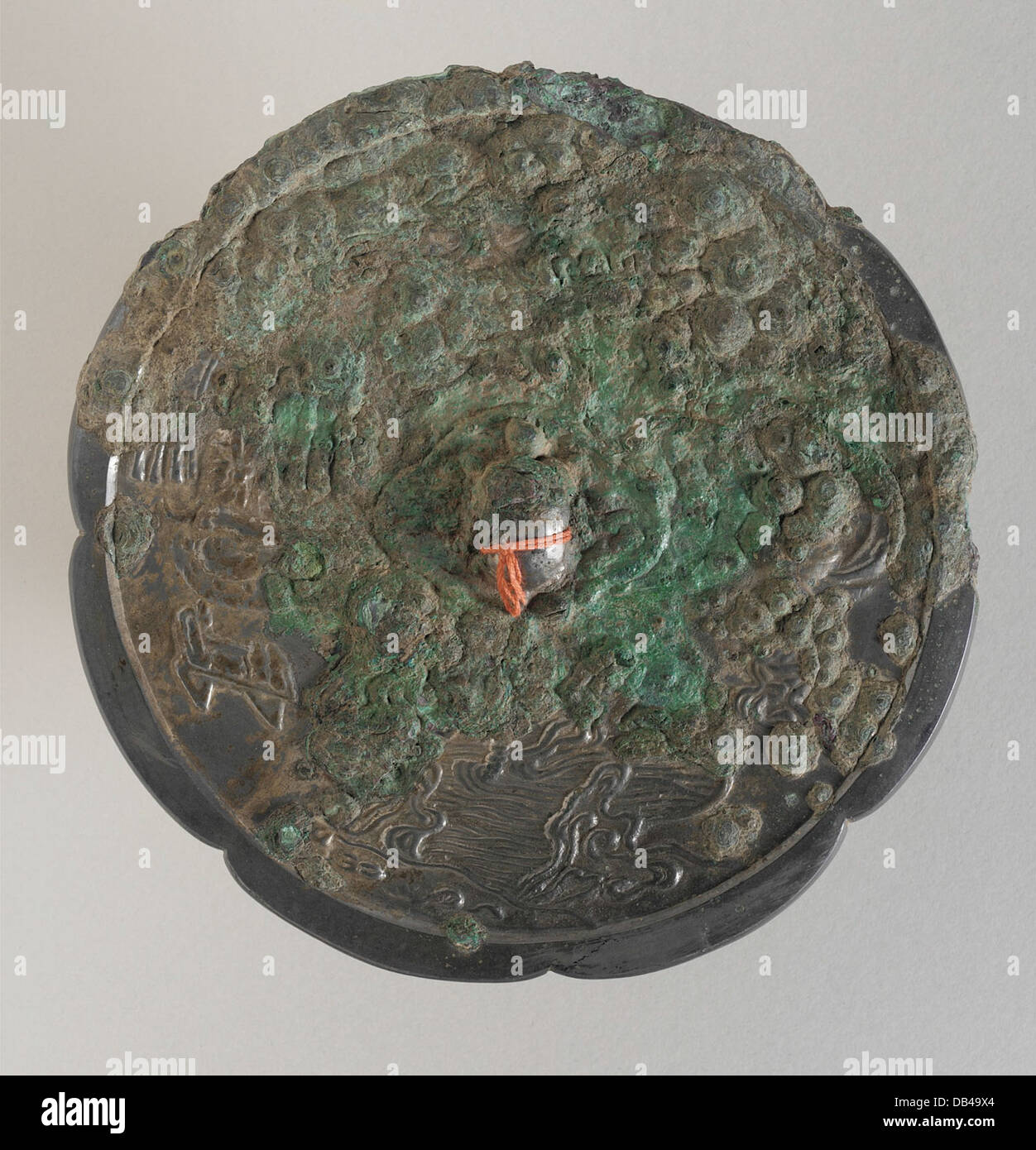 This Chinese mirror, called Jing, features an engraved landscape design ...