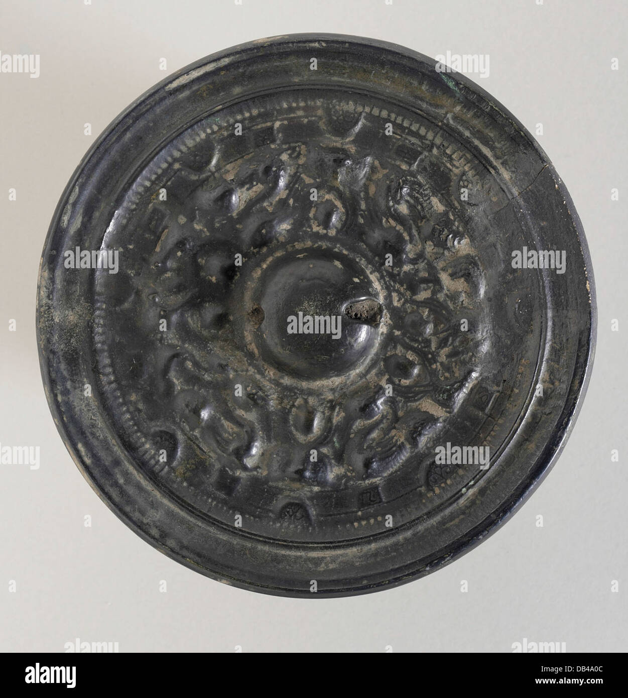 This ancient Chinese mirror (jing) features intricate designs of ...