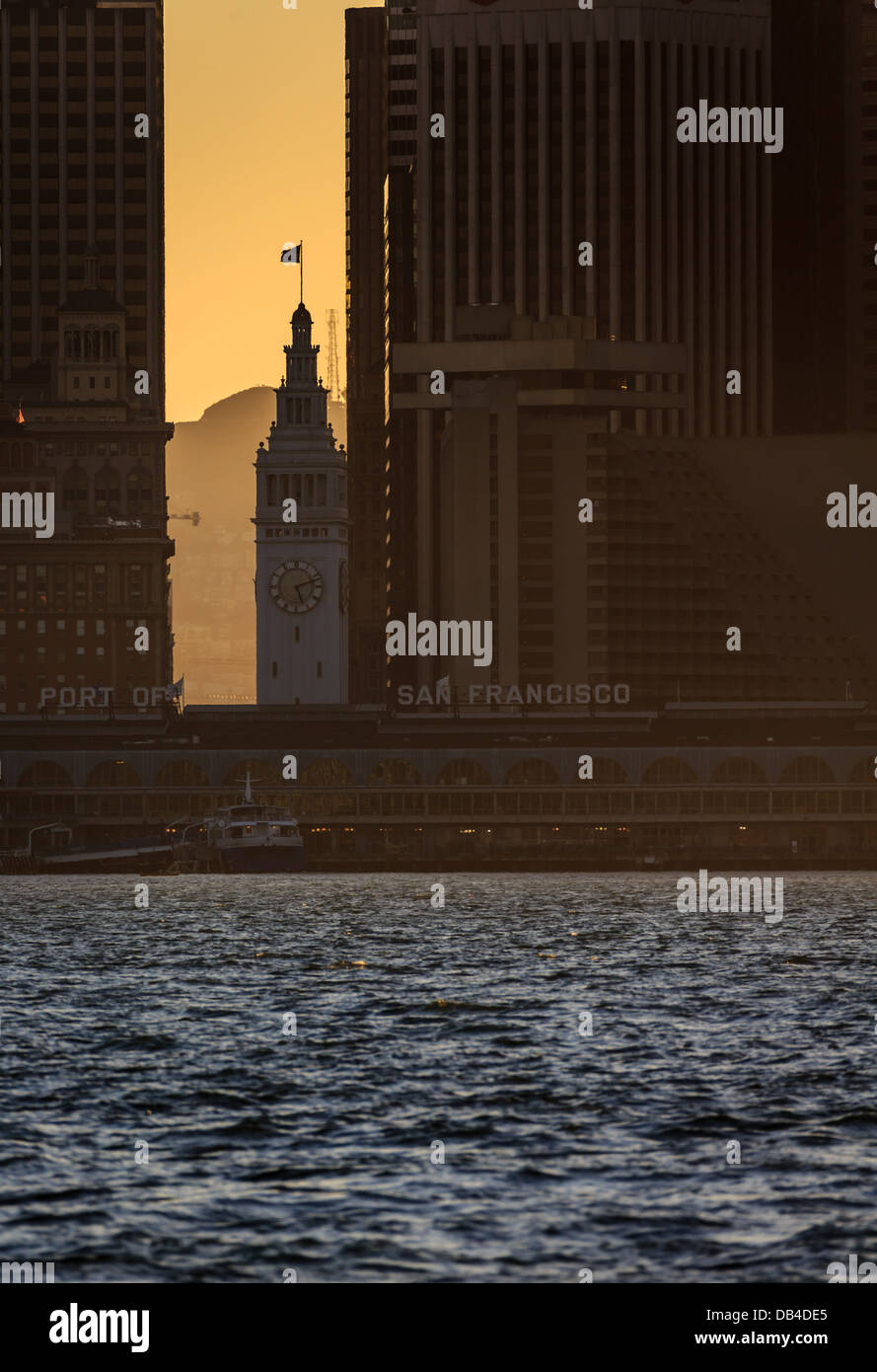 City sunset illuminates tower and silhouettes surrounding buildings in ...