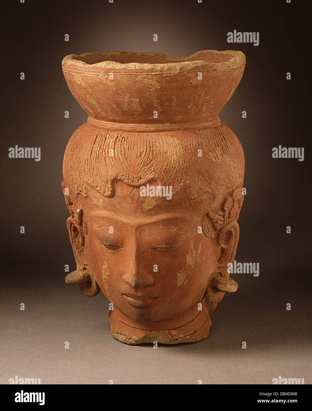 This offering vessel, shaped like a female head, is an ancient artifact ...