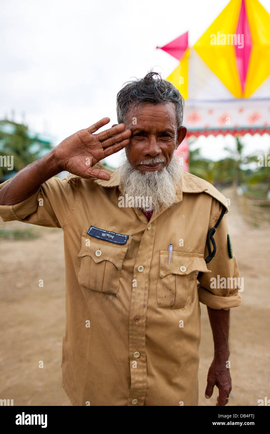 An old police man now a security guard salutes at Kuakata beach in the ...