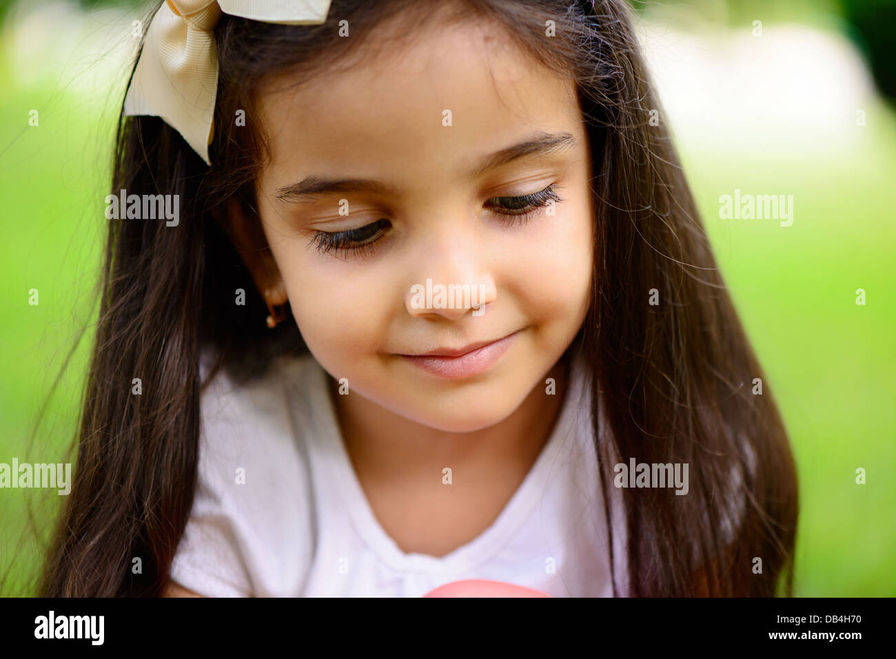 Portrait of hispanic girl with deep blue eyes in sunny park Stock Photo ...