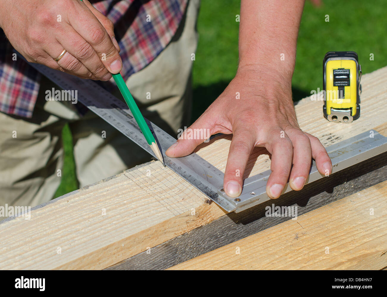 Male hands measuring and marking wooden plank outdoors Stock Photo - Alamy
