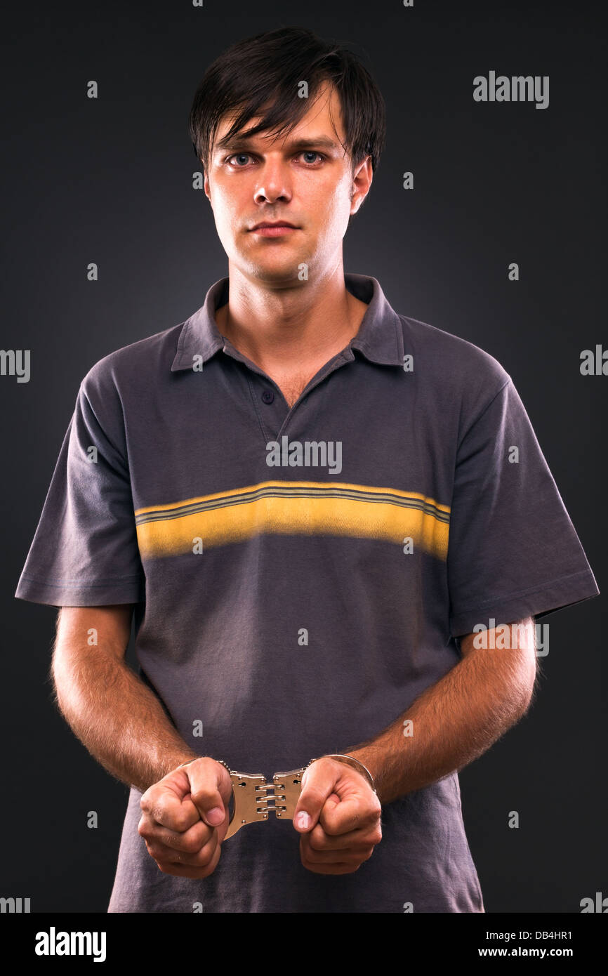 portrait of handcuffed man on gray backing Stock Photo - Alamy