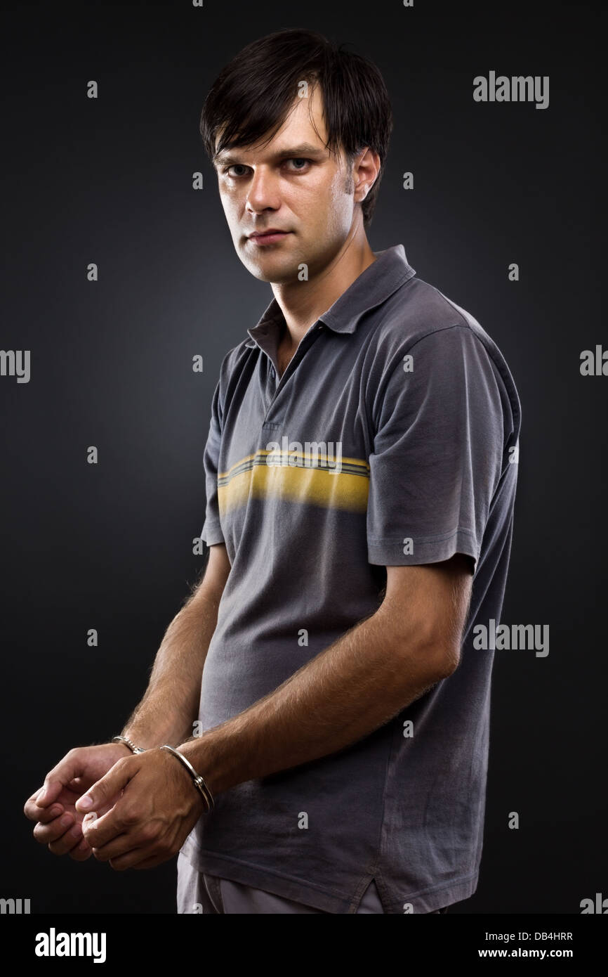 handcuffed man on gray backing Stock Photo - Alamy
