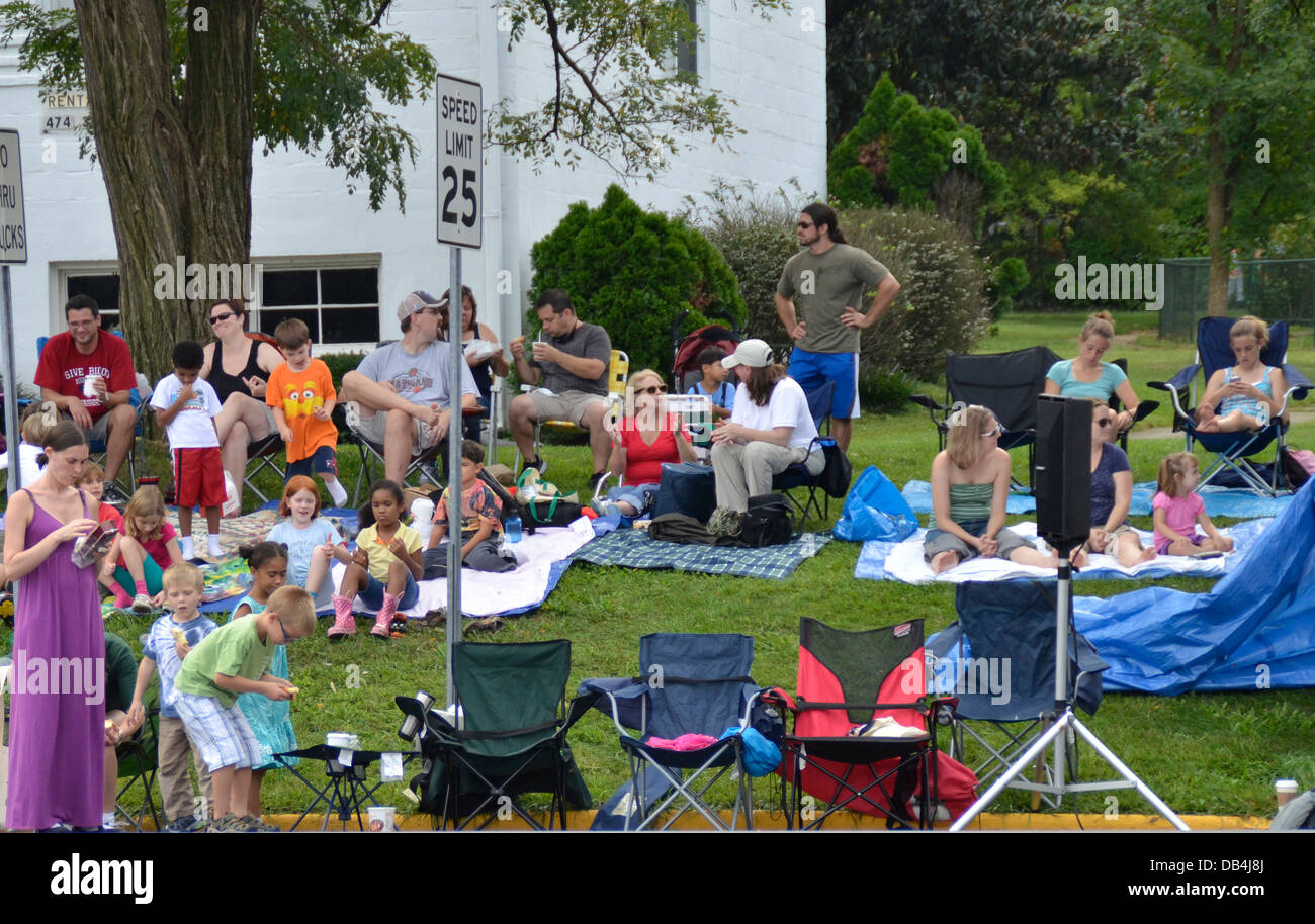 people sitting outside waiting for a parade Stock Photo - Alamy